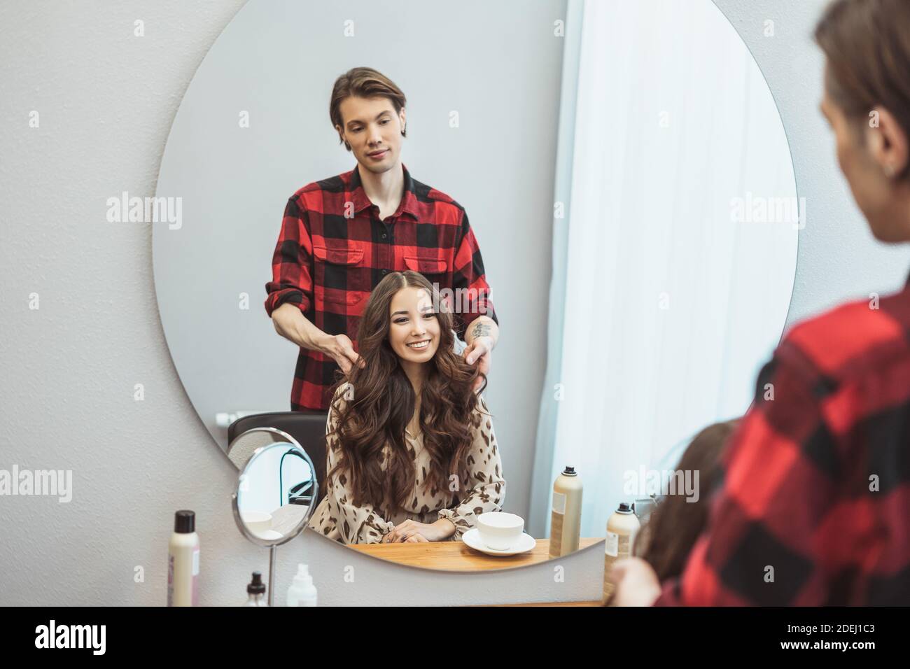Stylist barber styling long hair for beautiful asian young woman in the ...