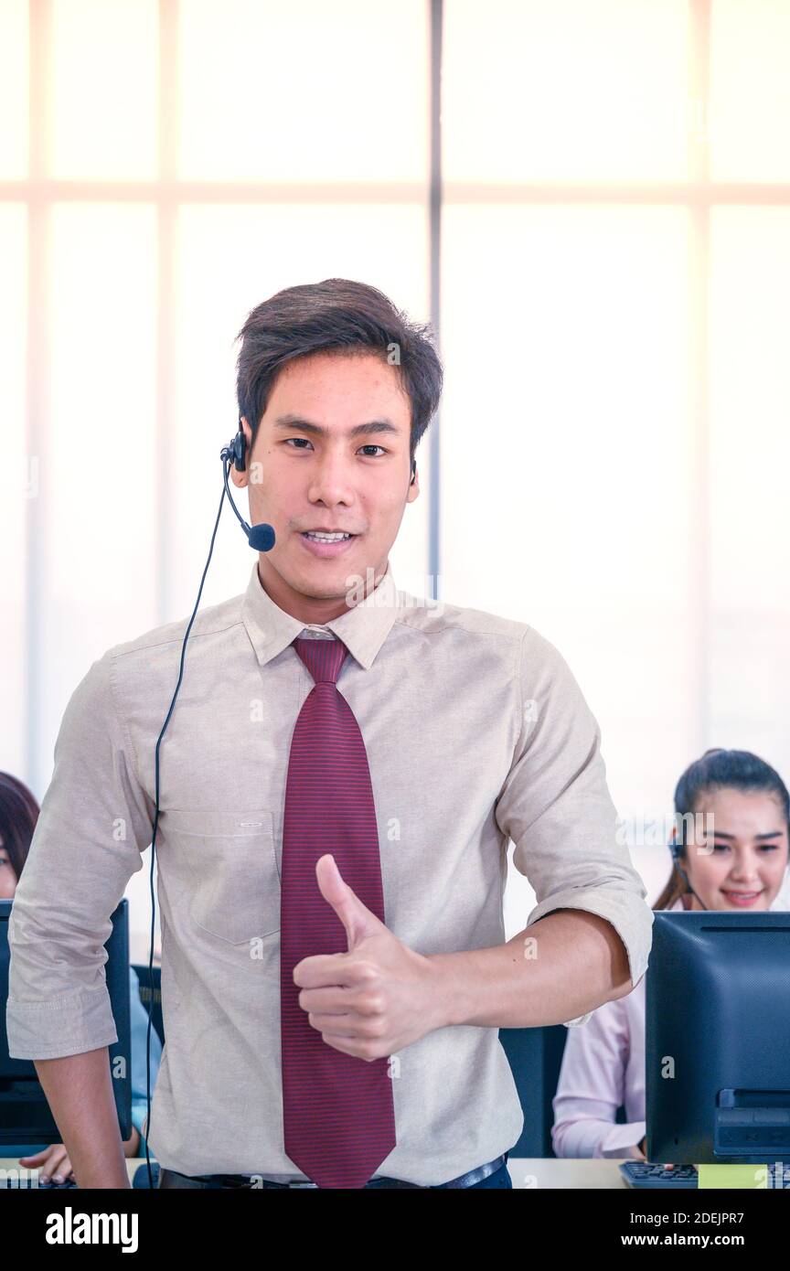 Young customer service men agent Thumbs up with headsets and computer ...