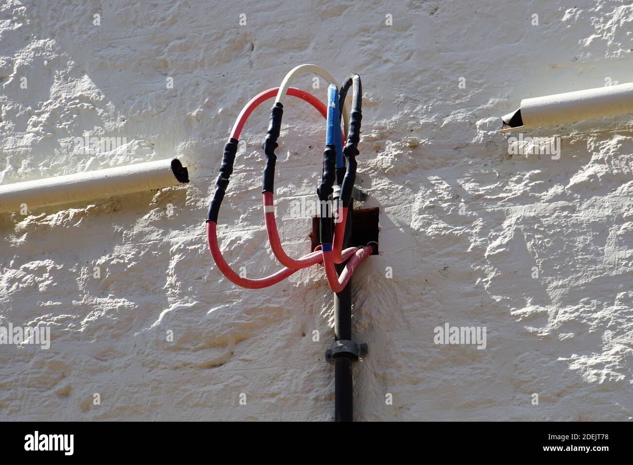 Multi-Colored Cables on an Exterior Wall illuminated by the Morning Sun ...