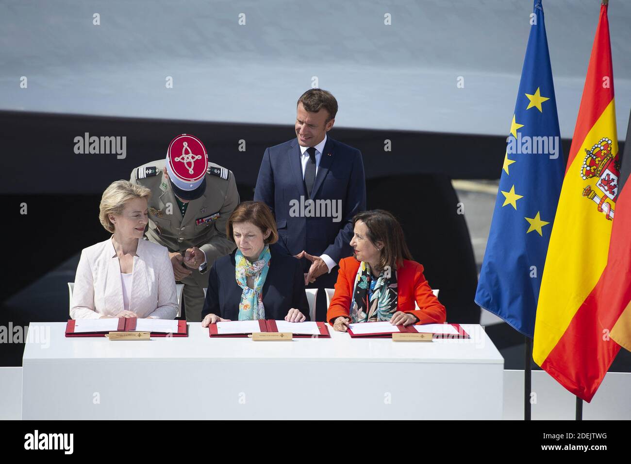 French President Emmanuel Macron (C) stands as German Defense Minister ...
