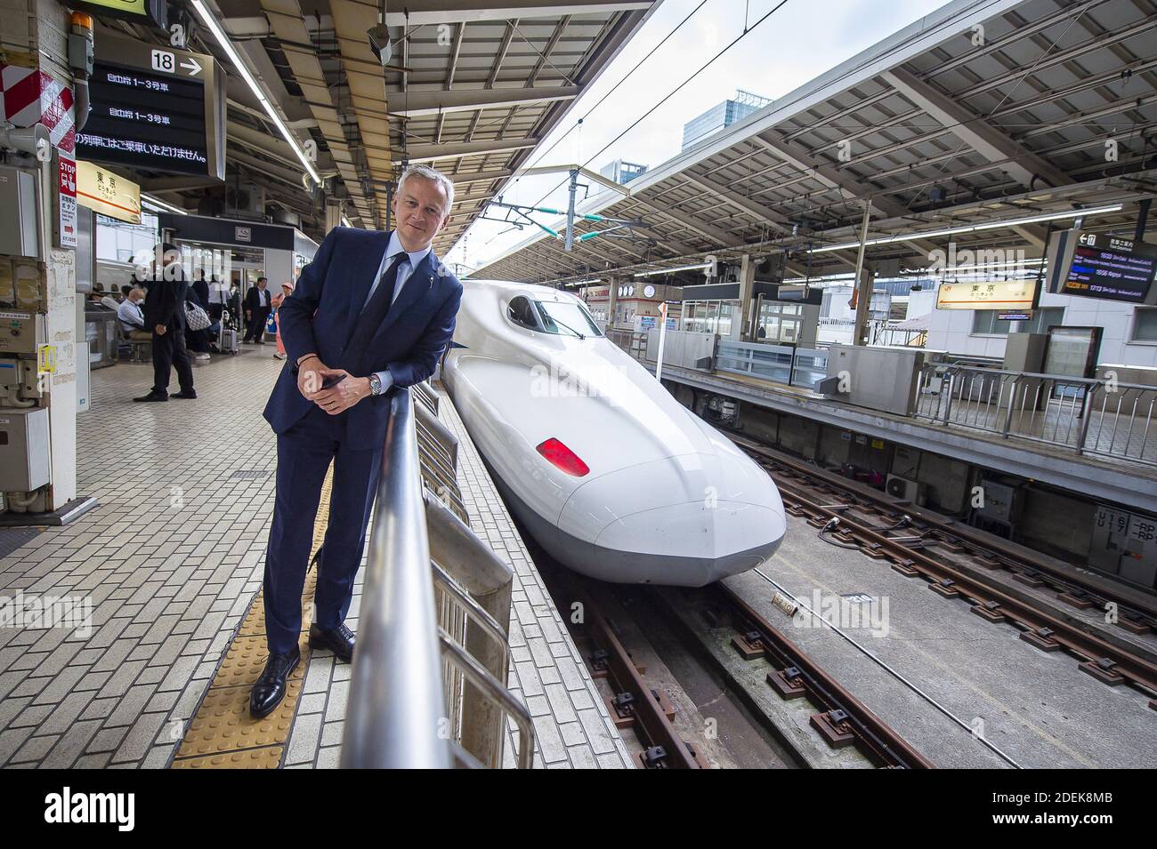 Bruno Le Maire arrives at a train station and poses in front of ...