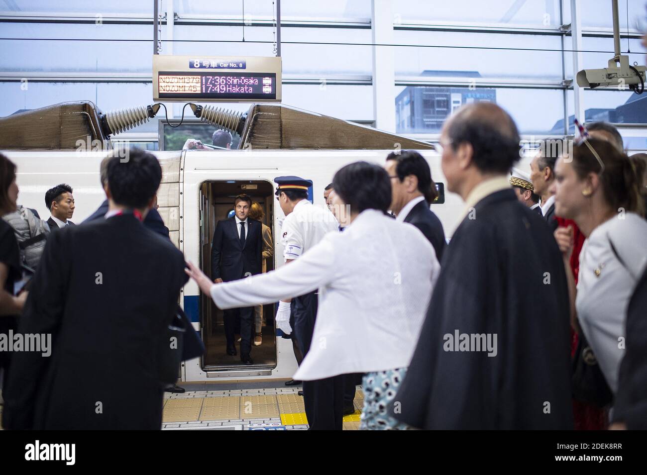 France's President Emmanuel Macron (L) is greeted by a maiko ...