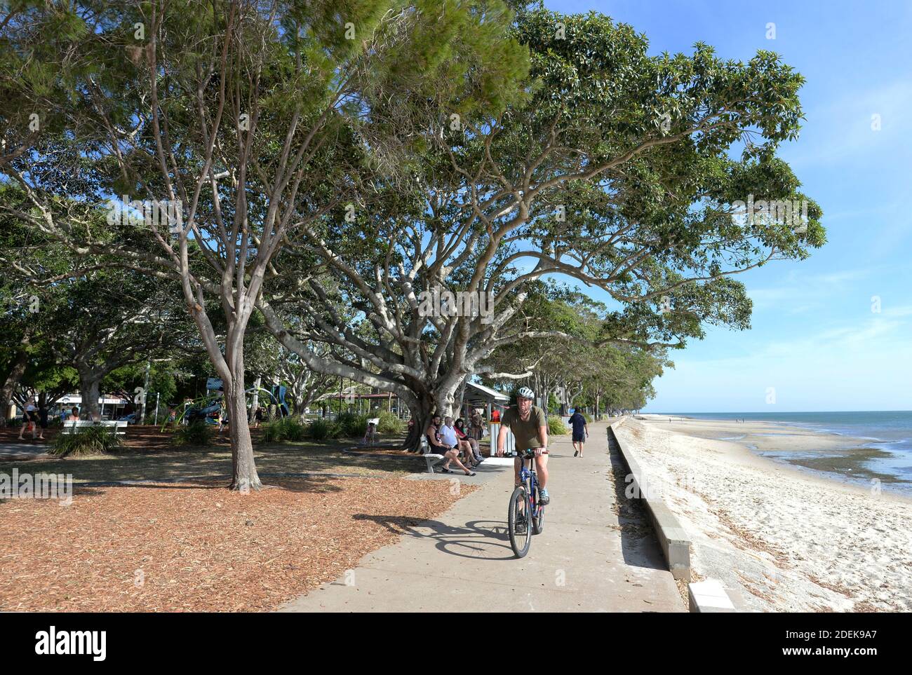 People and cyclist relaxing on the seafront at popular Bongaree Beach, Bribie Island, Sunshine ...
