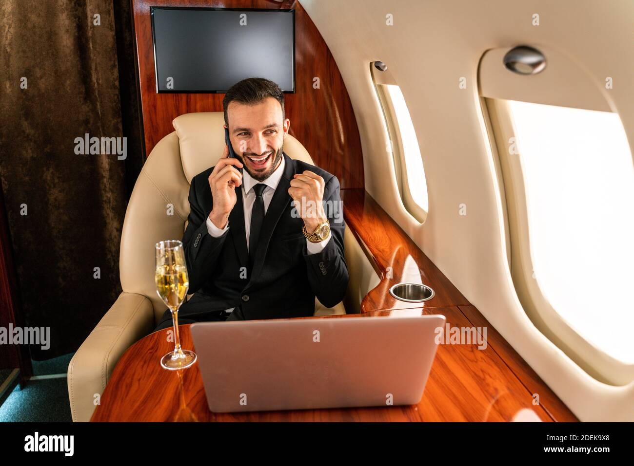Handsome businessman wearing elegant suit flying on exclusive private ...