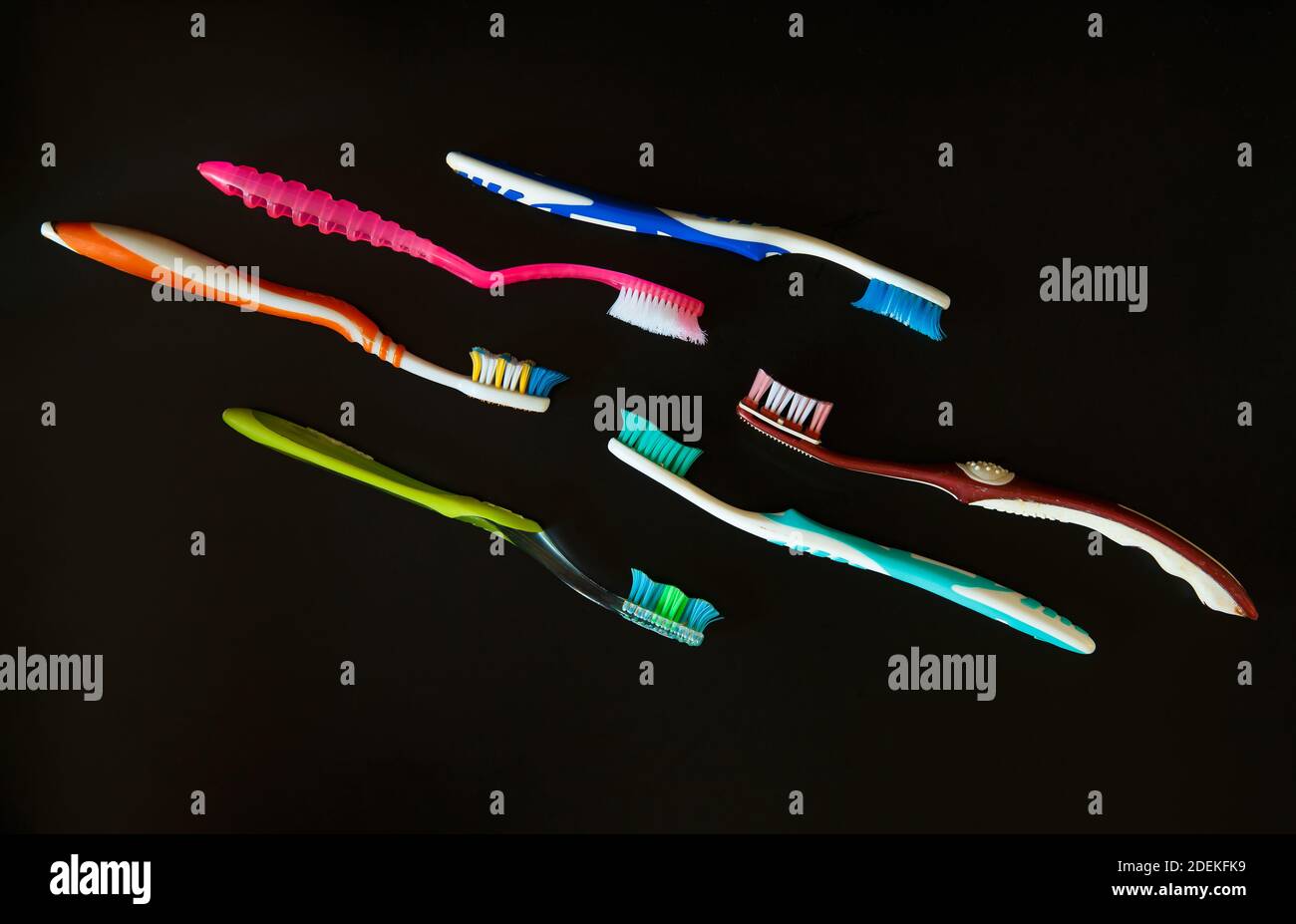 Used plastic toothbrushes on a black background. Ecology and waste ...