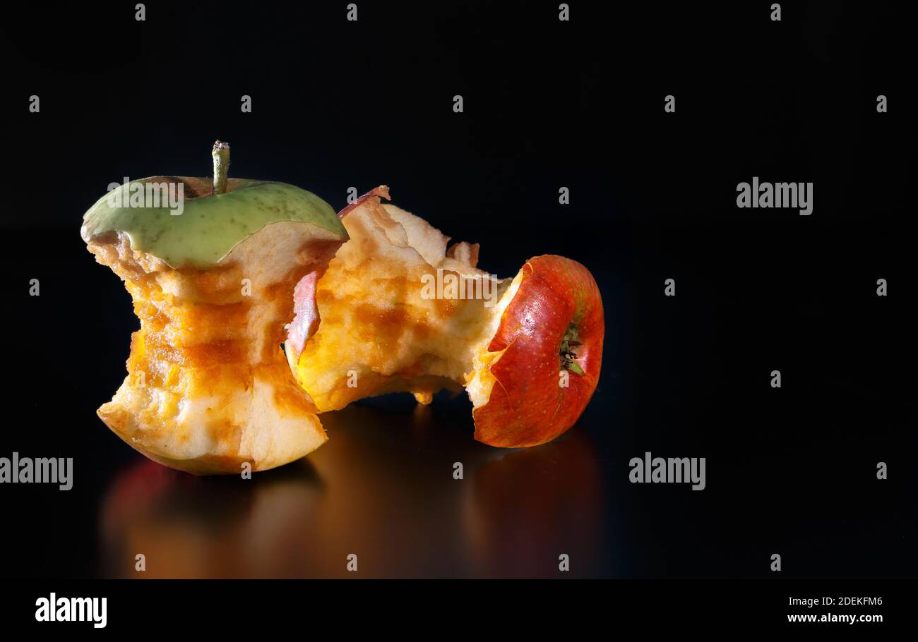 An apple core on a black background with reflexion. Ecology and garbage ...