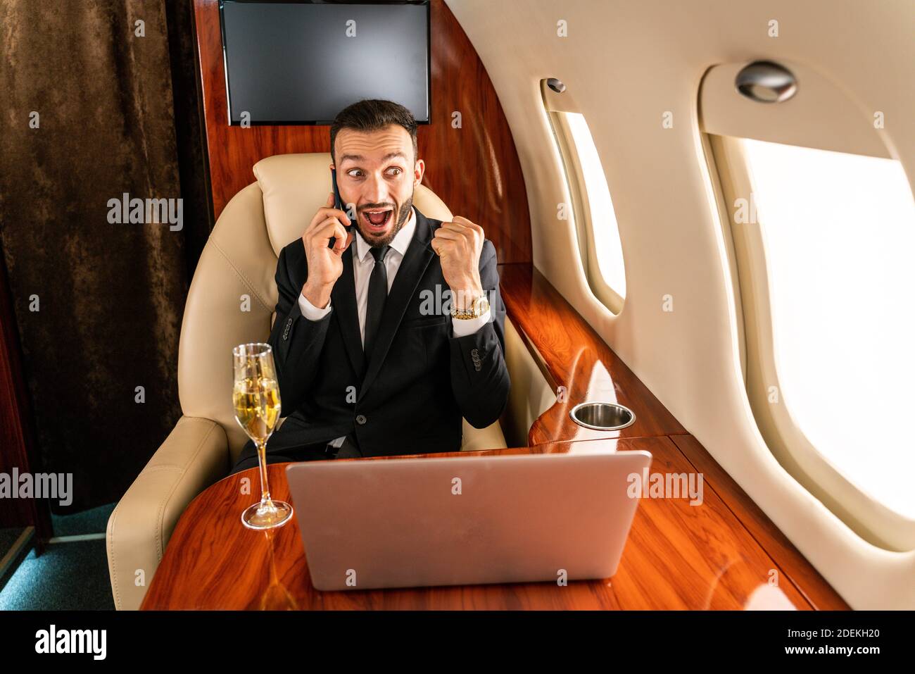 Handsome businessman wearing elegant suit flying on exclusive private ...