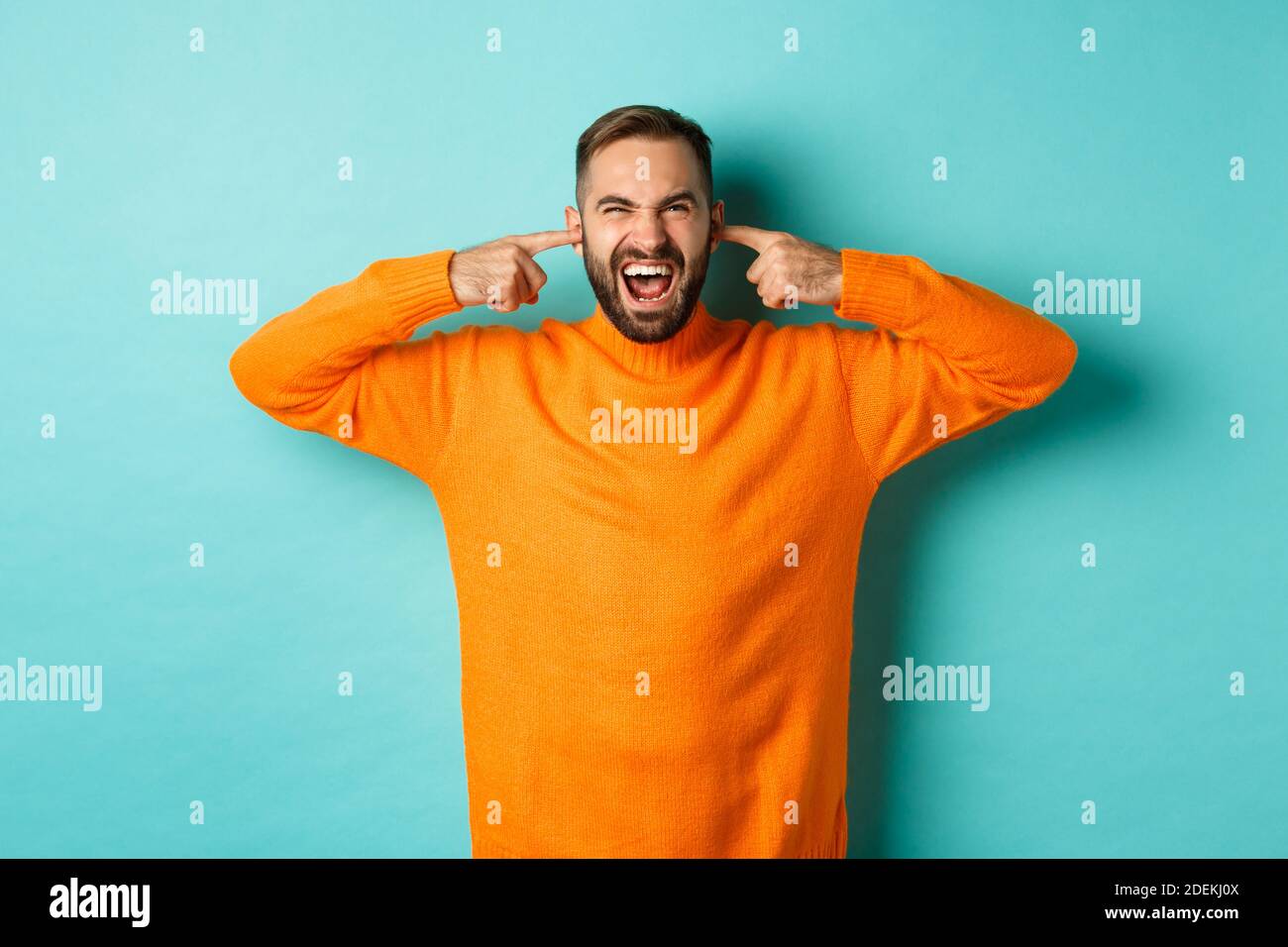 Displeased man shut ears and grimacing, loud neighbours, standing ...