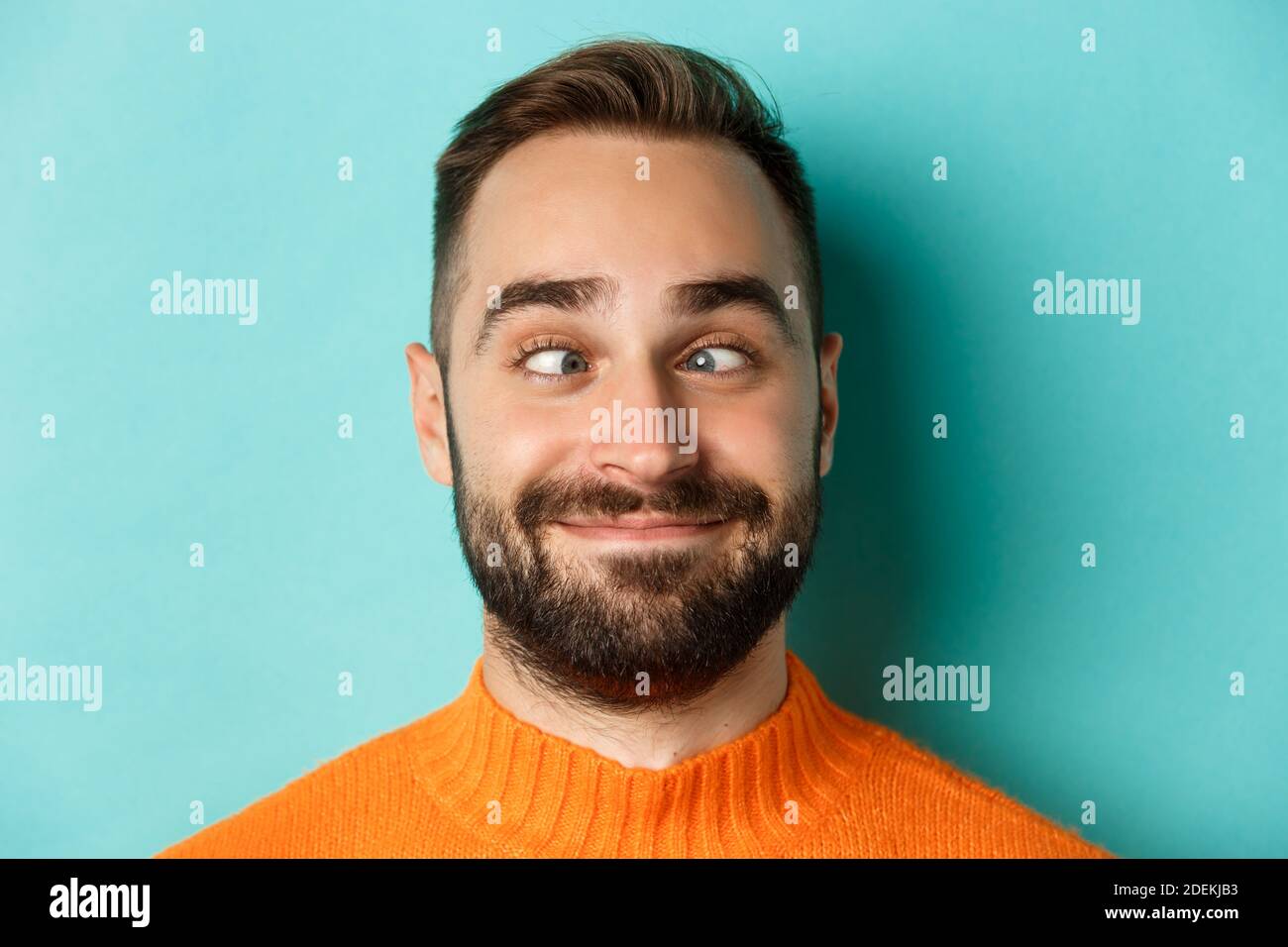 Headshot of funny caucasian man making faces, squinting and smiling ...