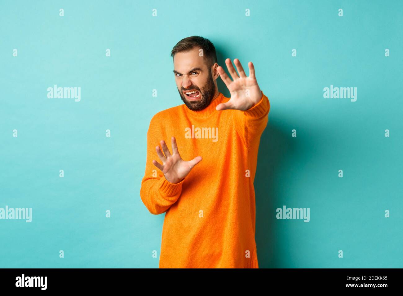 Disgusted man cringe and extending hands in protection, begging for ...