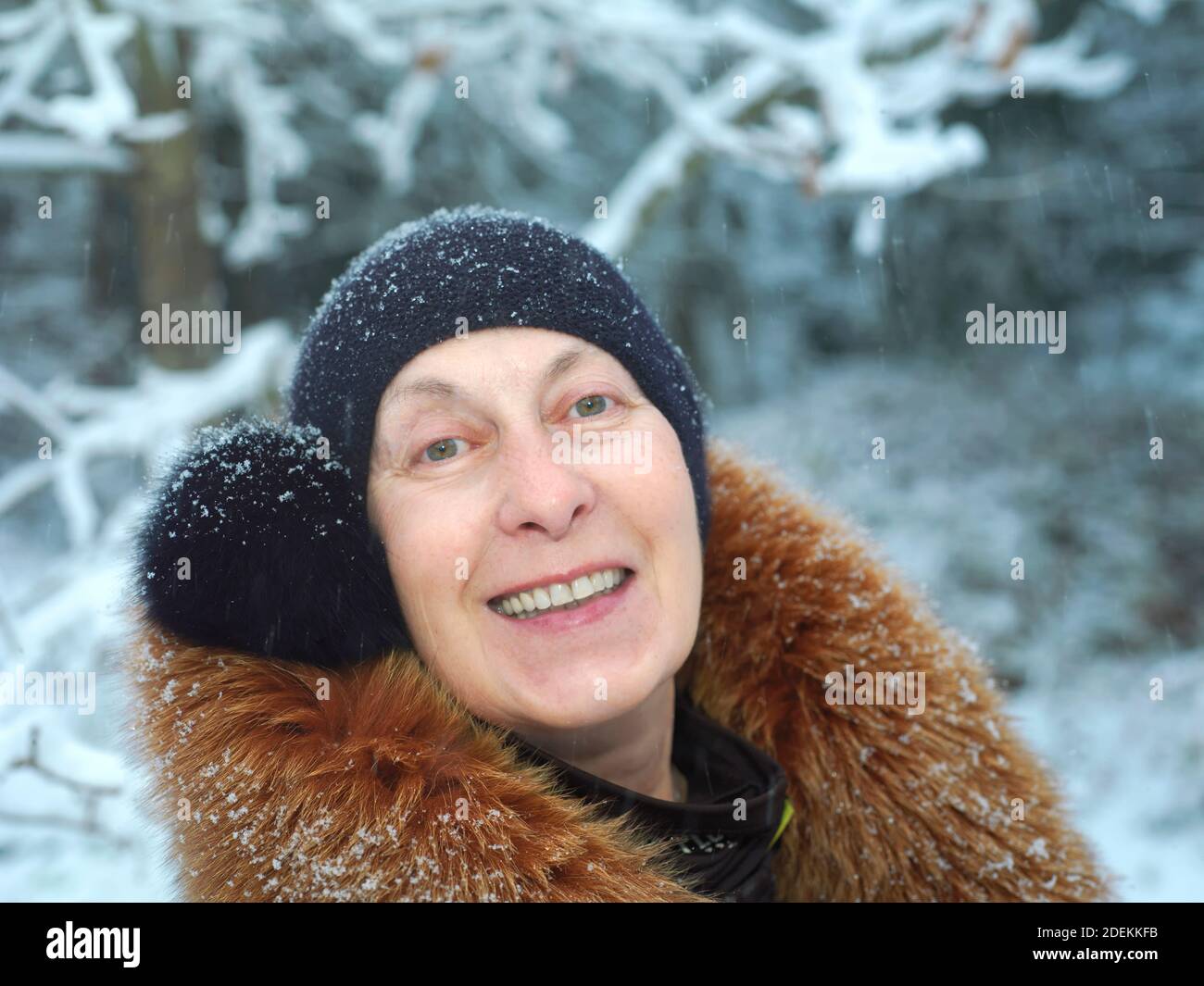Positive looking woman wearing fur coat posing in a winter forest Stock ...