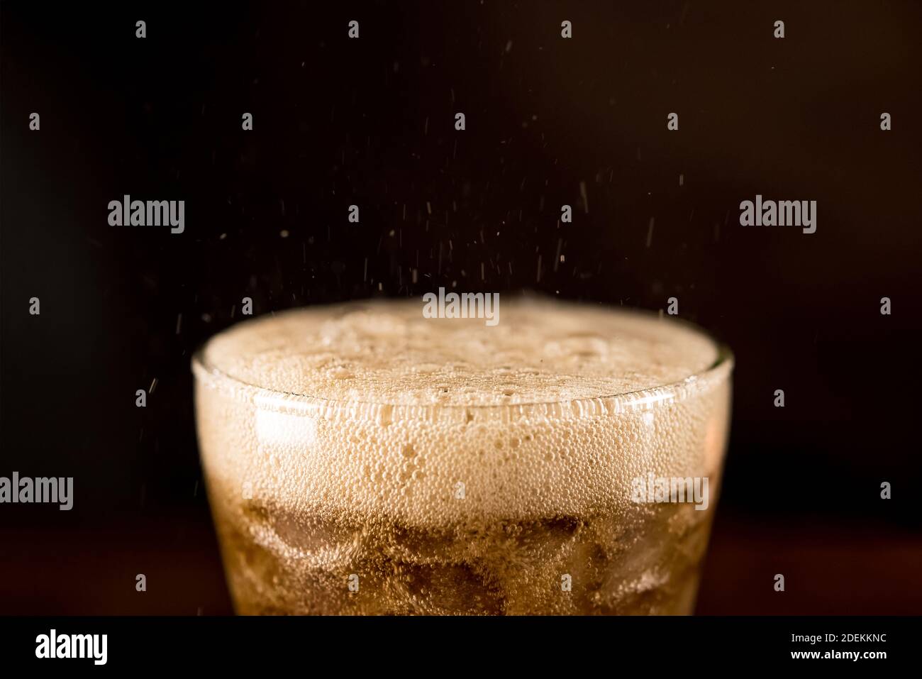 Close up of cold sparking cola sodar soft drink in the glass with foam ...