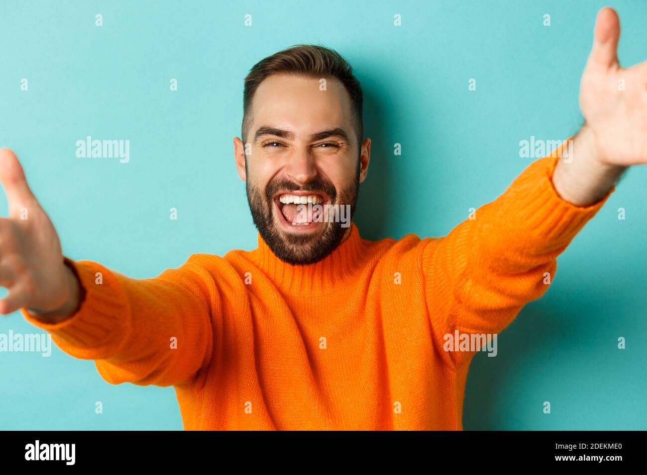 Close-up of handsome happy man reaching hands forward, stretching arms ...