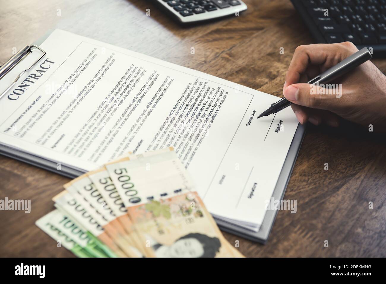 Businessman signing contract with thousands of South Korean won money ...