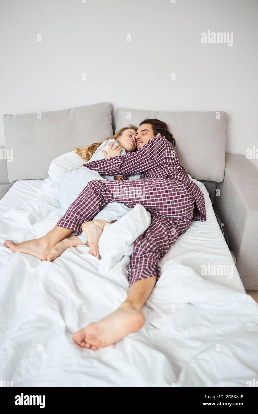 Beautiful young couple sleeping and cuddling at home Stock Photo - Alamy