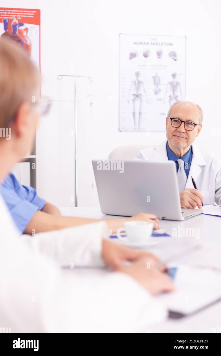 Medical expert talking with medical staff during healthcare meeting in ...