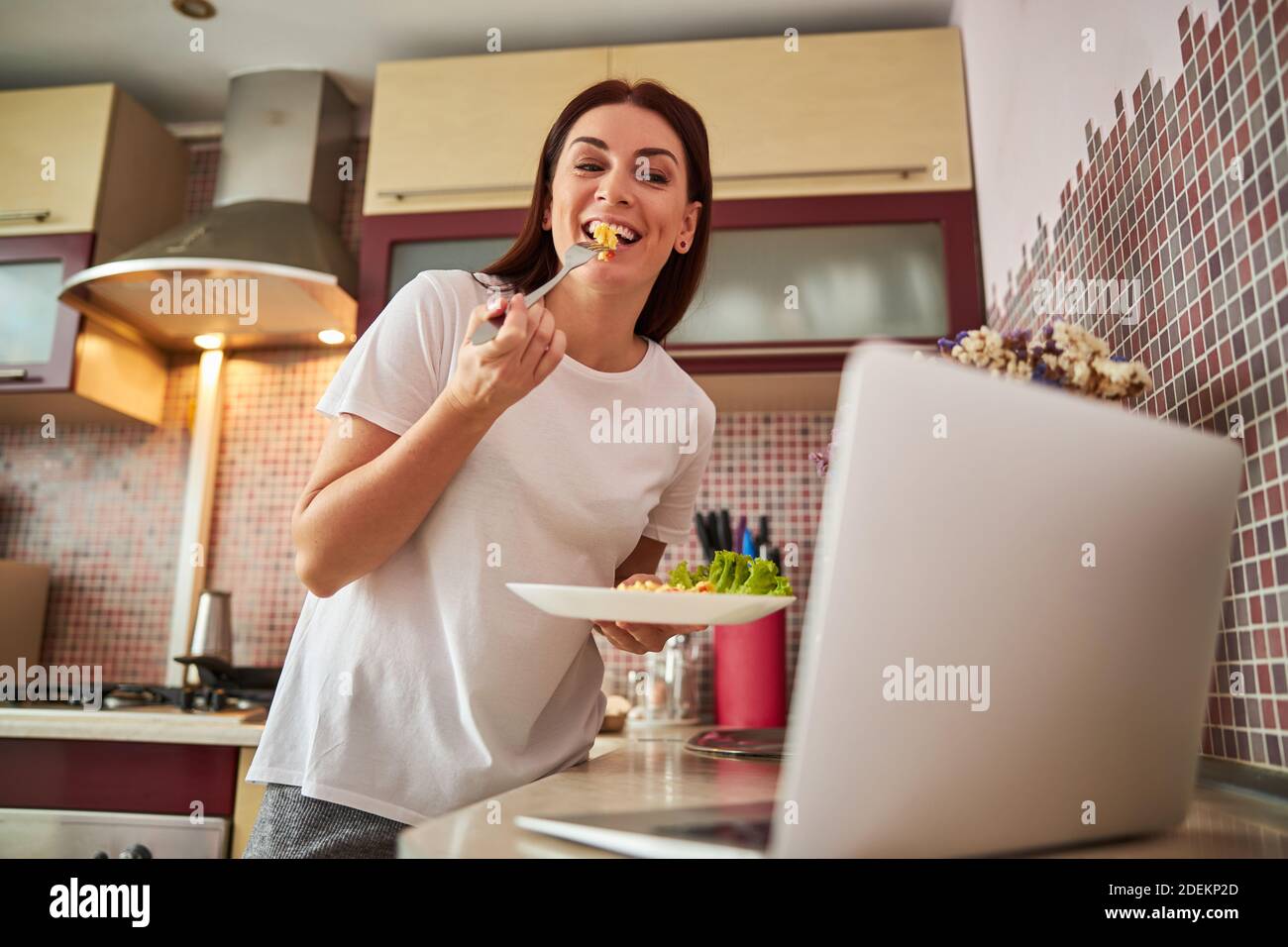 Cook putting a piece of food in her mouth Stock Photo - Alamy