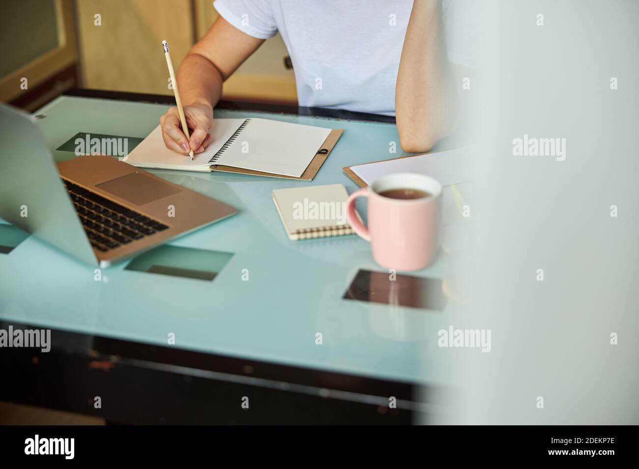 Person making notes with a pencil in a notepad Stock Photo - Alamy