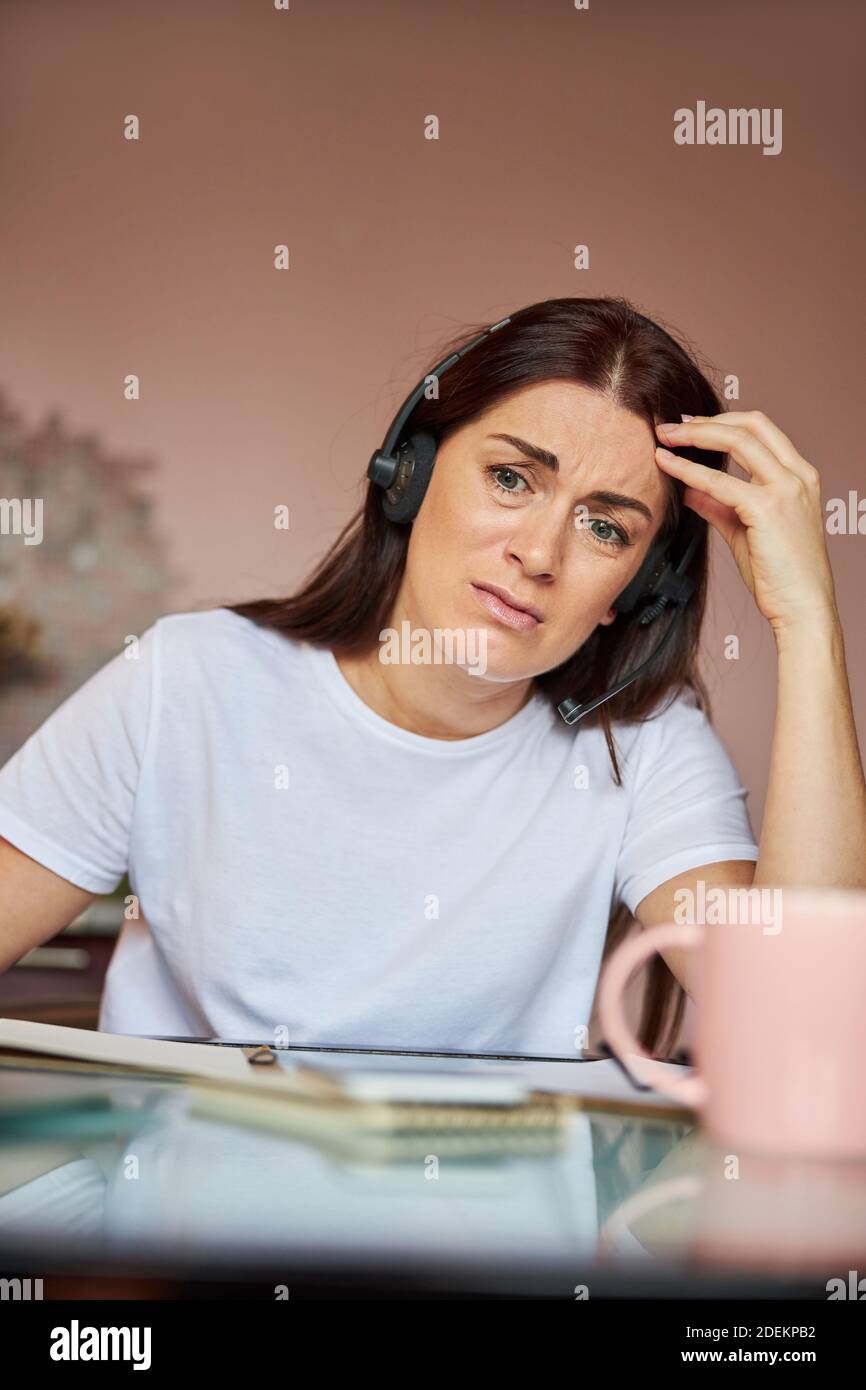 Upset freelance worker staring sadly at her work task Stock Photo - Alamy