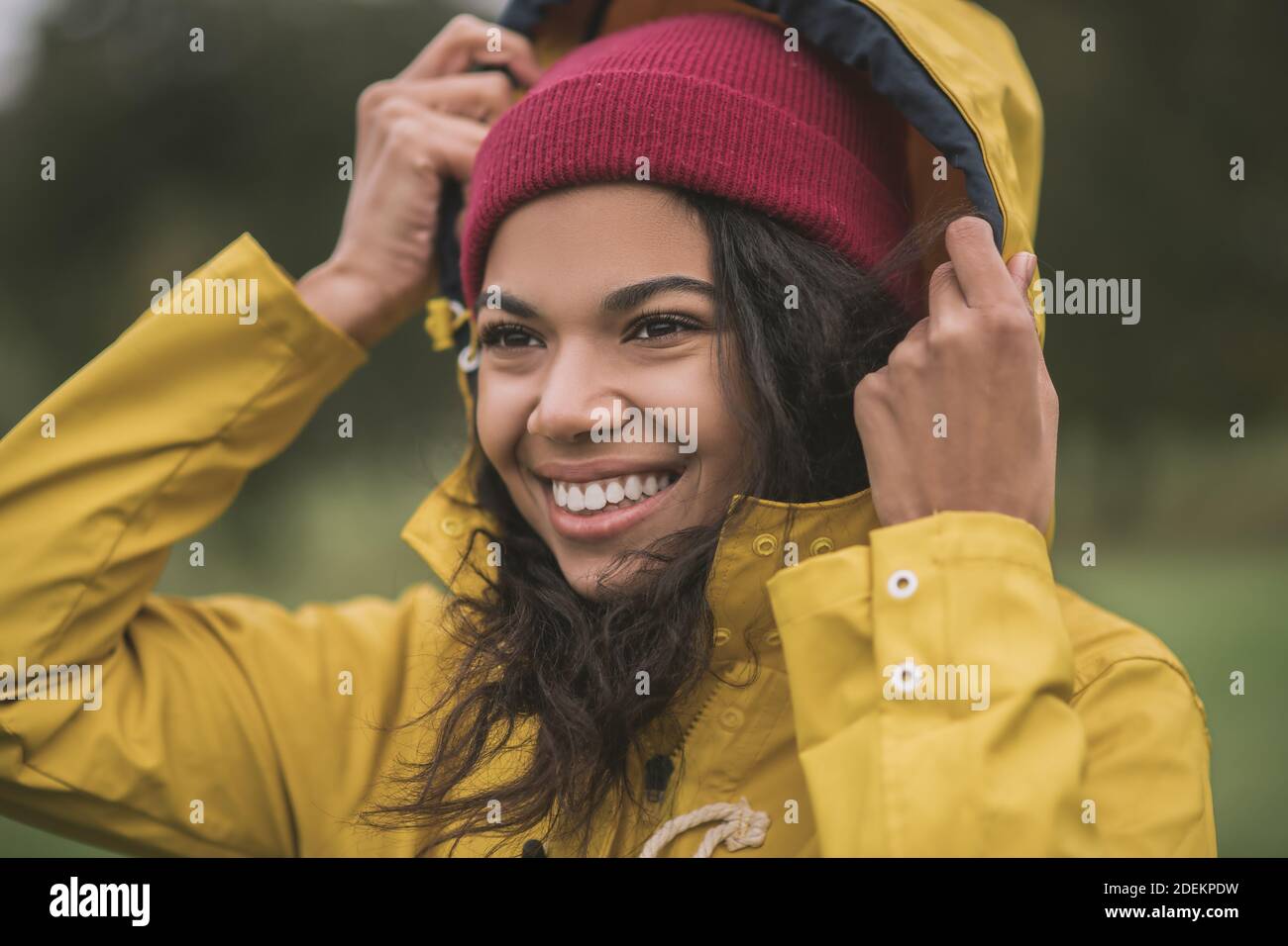 Pretty mulatta in yellow coat smiling nicely Stock Photo - Alamy