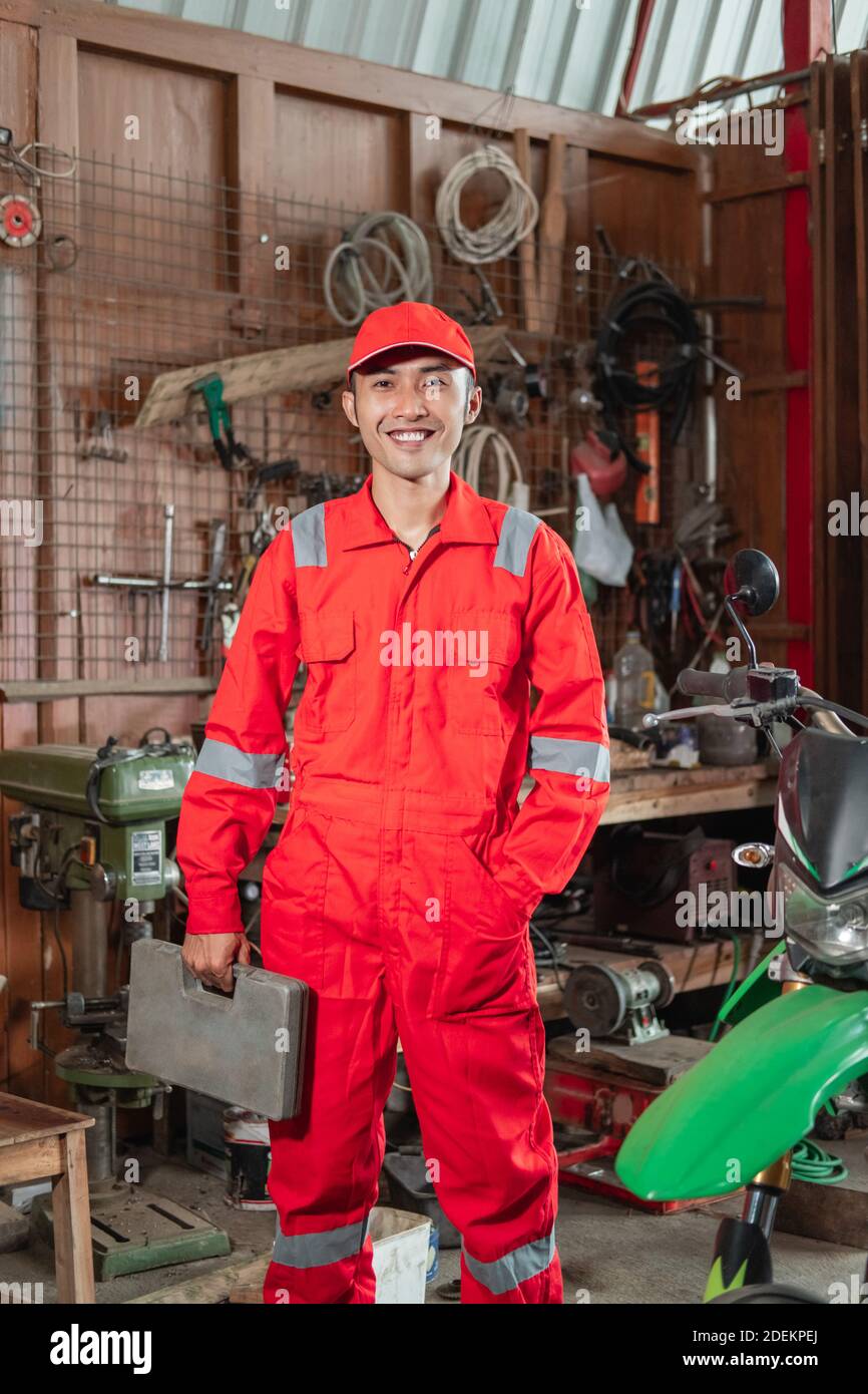 mechanic wearing the wearpack stands carrying the toolbox in the ...