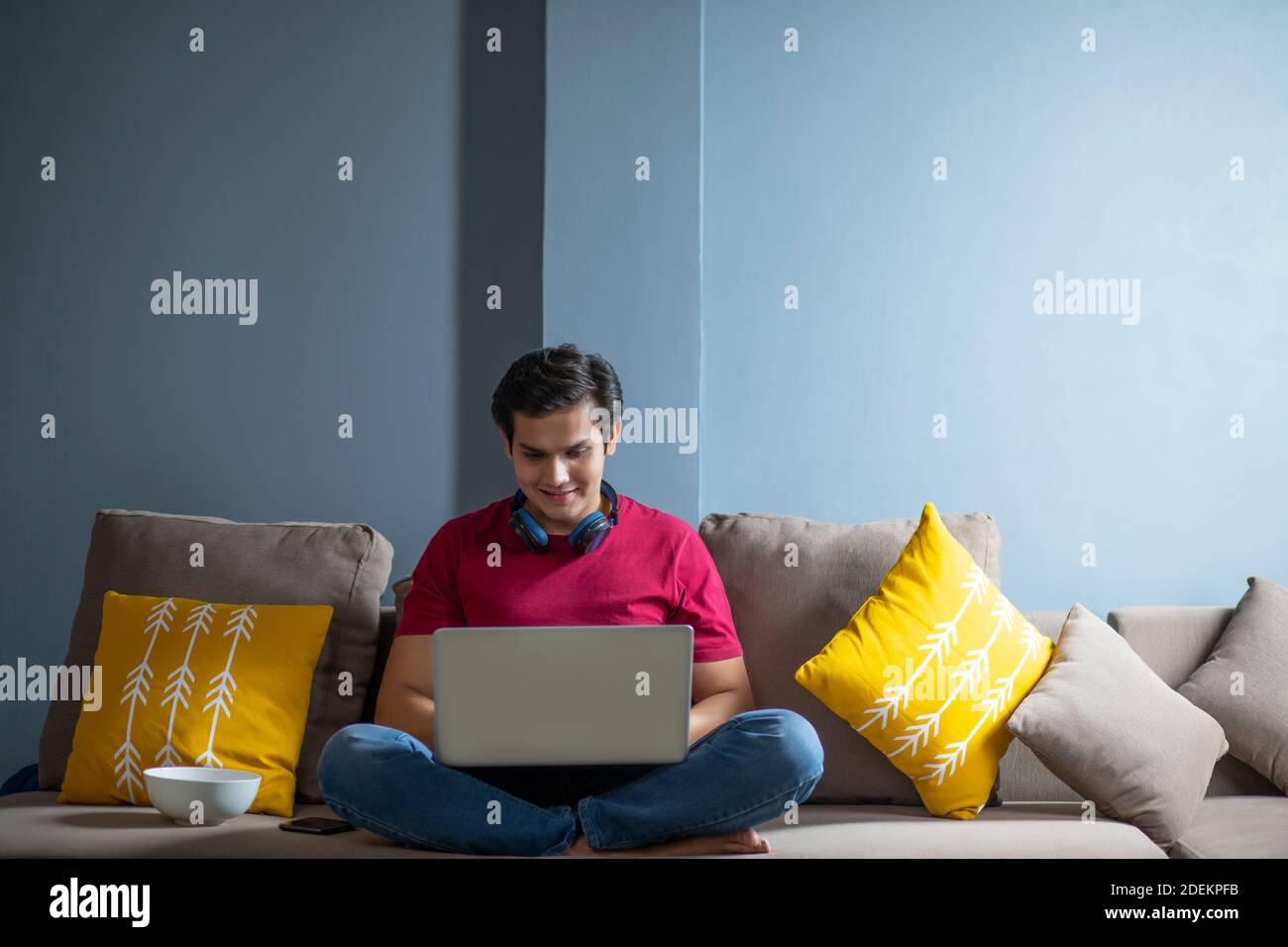 A YOUNG MAN DOING RESEARCH WORK FOR HIS ASSIGNMENT WITH HEAPHONES ...