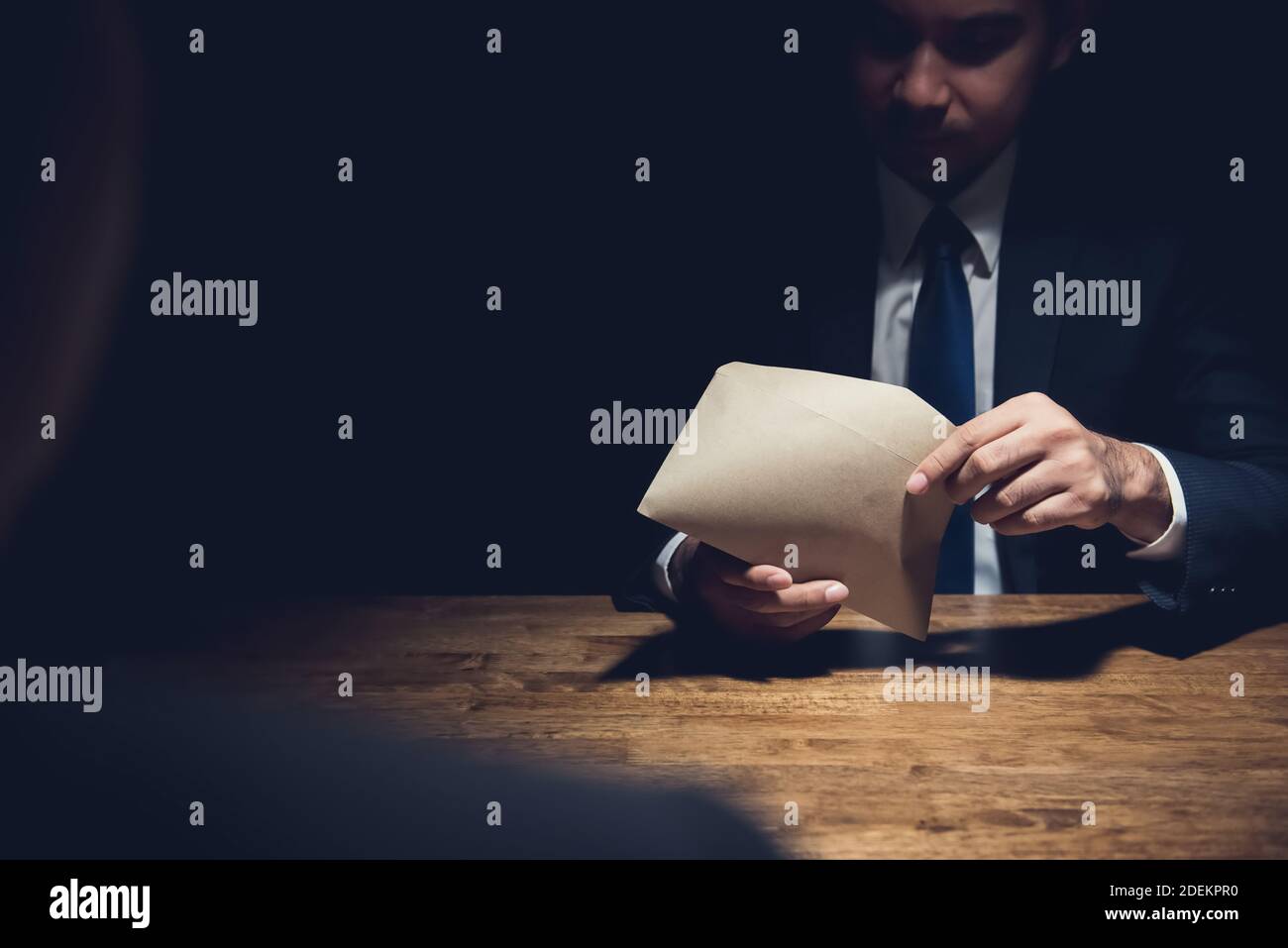 Businessman checking money in the envelope given by his partner as a ...