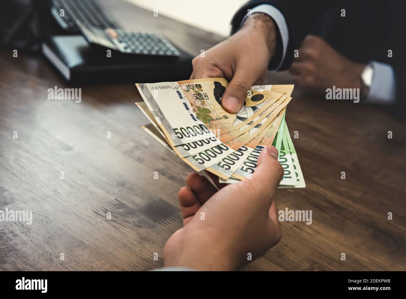 Businessman receiving money, South Korean WON currency bills, hand to ...