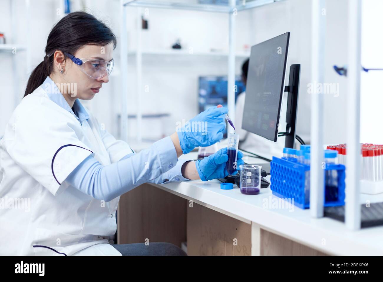 Young scientist loads pipette with sample for dna examination in ...