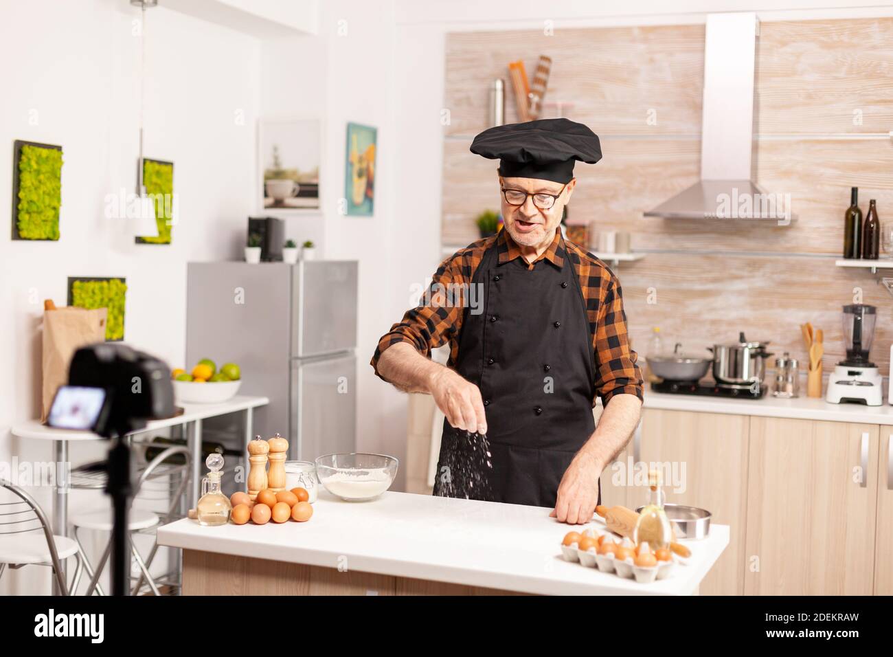 Experienced senior chef recording tutorial with food preparation in ...