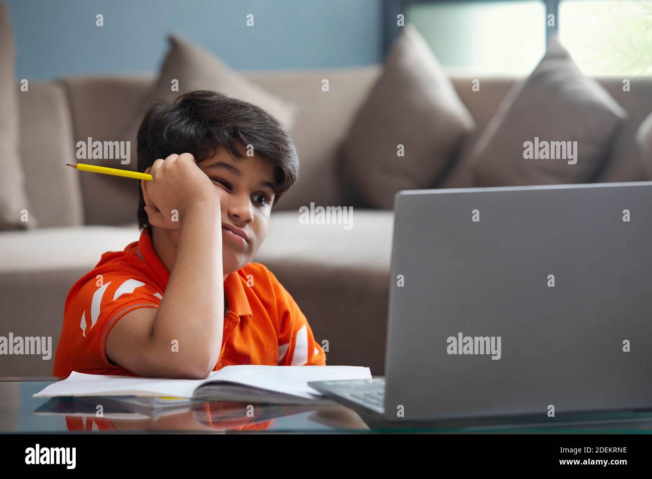 A YOUNG BOY TRYING TO CONCENTRATE DURING ONLINE CLASS Stock Photo - Alamy