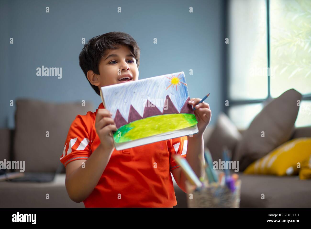 Young boy showing artwork he made at home Stock Photo - Alamy
