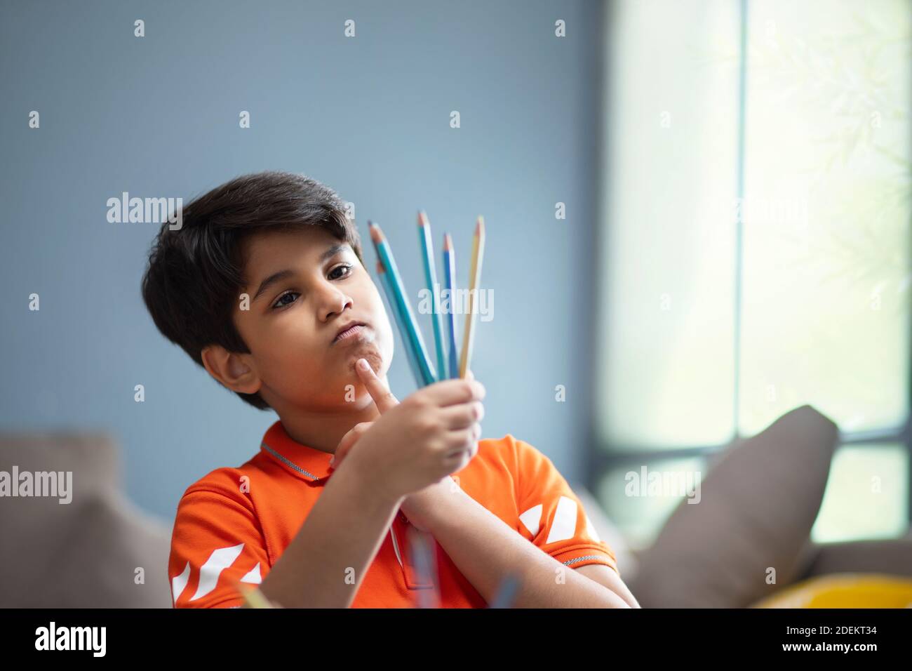 Boy looking at different colors in doubt trying to figure out which one ...