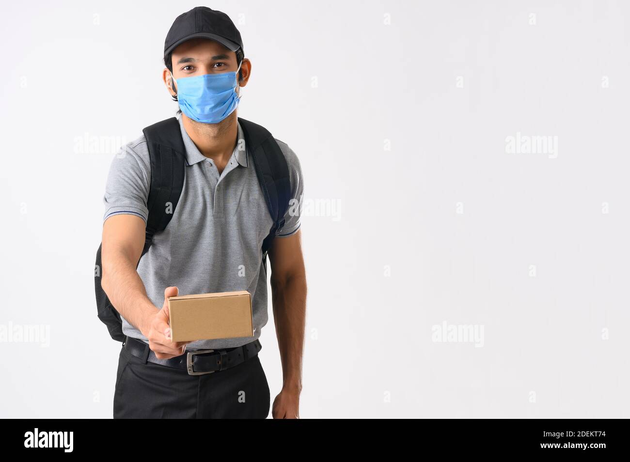 Delivery boy delivering parcel with precautions Stock Photo - Alamy