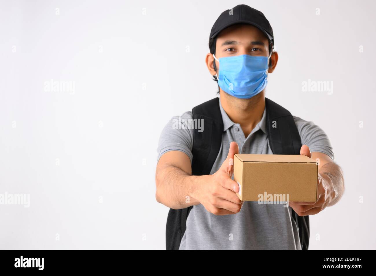 Delivery boy delivering parcel with precautions Stock Photo - Alamy
