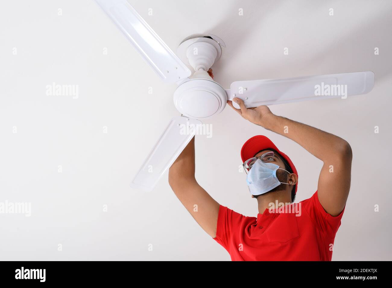 Electrician looking at a fan to examine it's problem Stock Photo - Alamy
