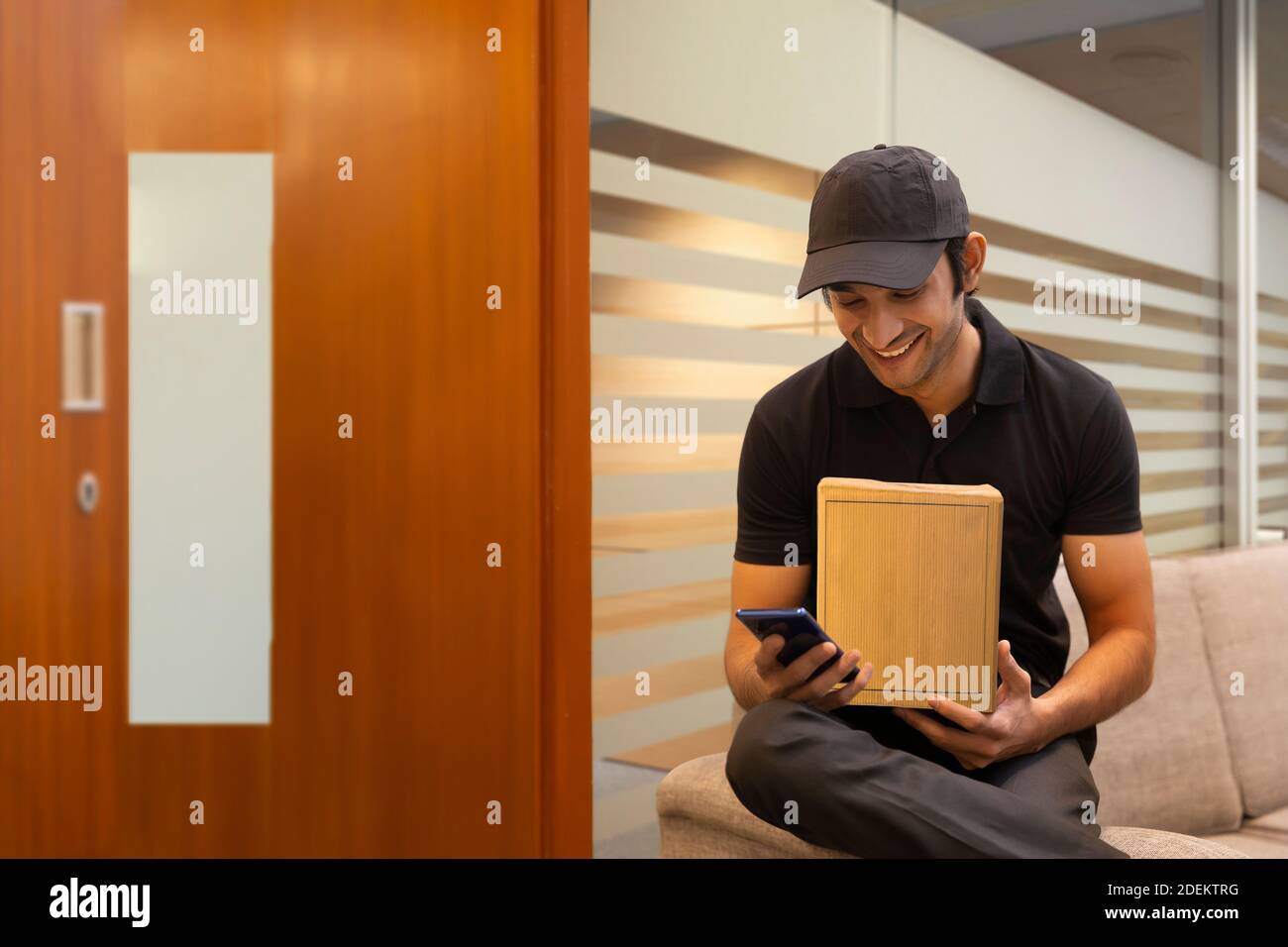 Delivery person smiling at his phone while waiting for the customer in ...