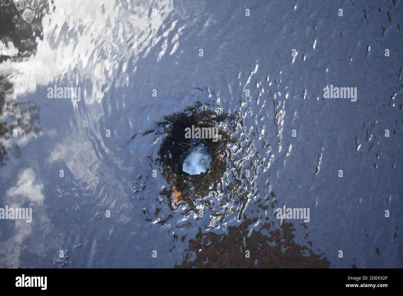 a top view of a drainage hole in a bridge near a waterfall on the ...