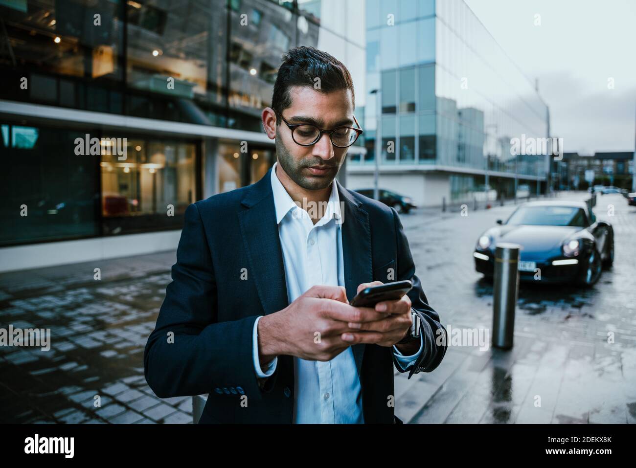 Mixed race businessman texting on smartphone dressed smartly while ...