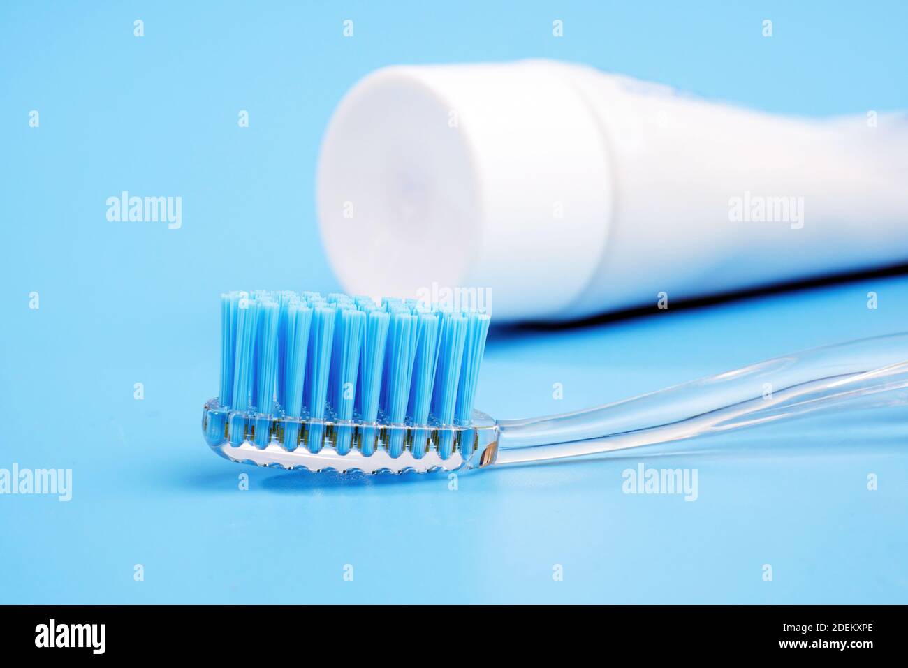toothbrush and white closed toothpaste tube on blue background Stock ...