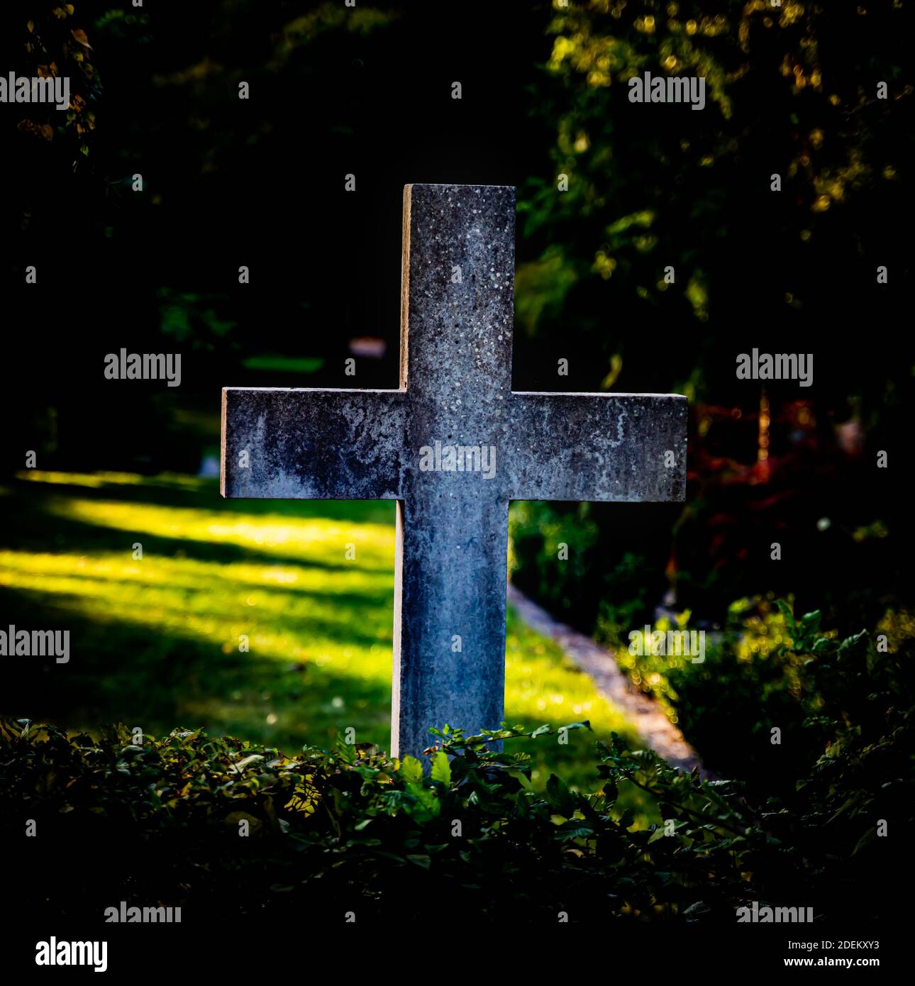 Old and weathered Christian stone cross tombstone in a moody ...