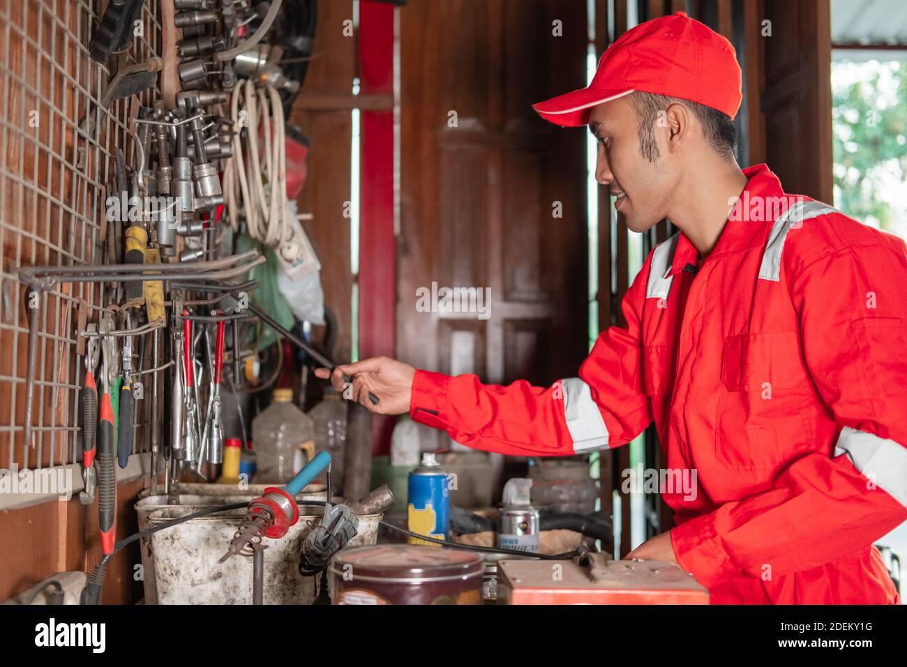 side view of mechanics in wearpacks putting workshop equipment on a ...