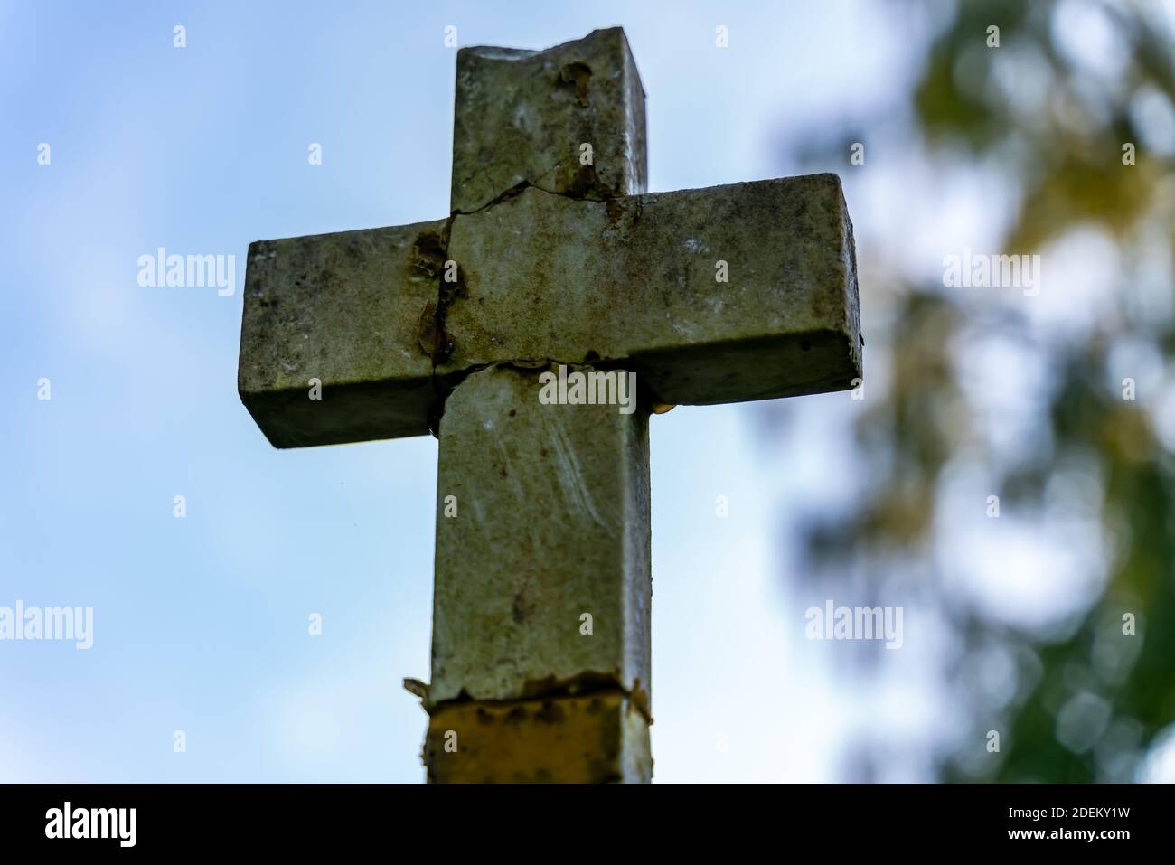 Old and cracked stone cross, a symbol of Christianity, close up with ...