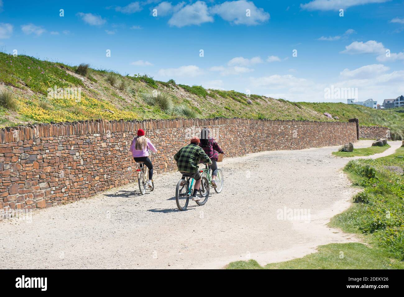 People enjoying a bicycle ride along a path on overlooking Fistral in ...
