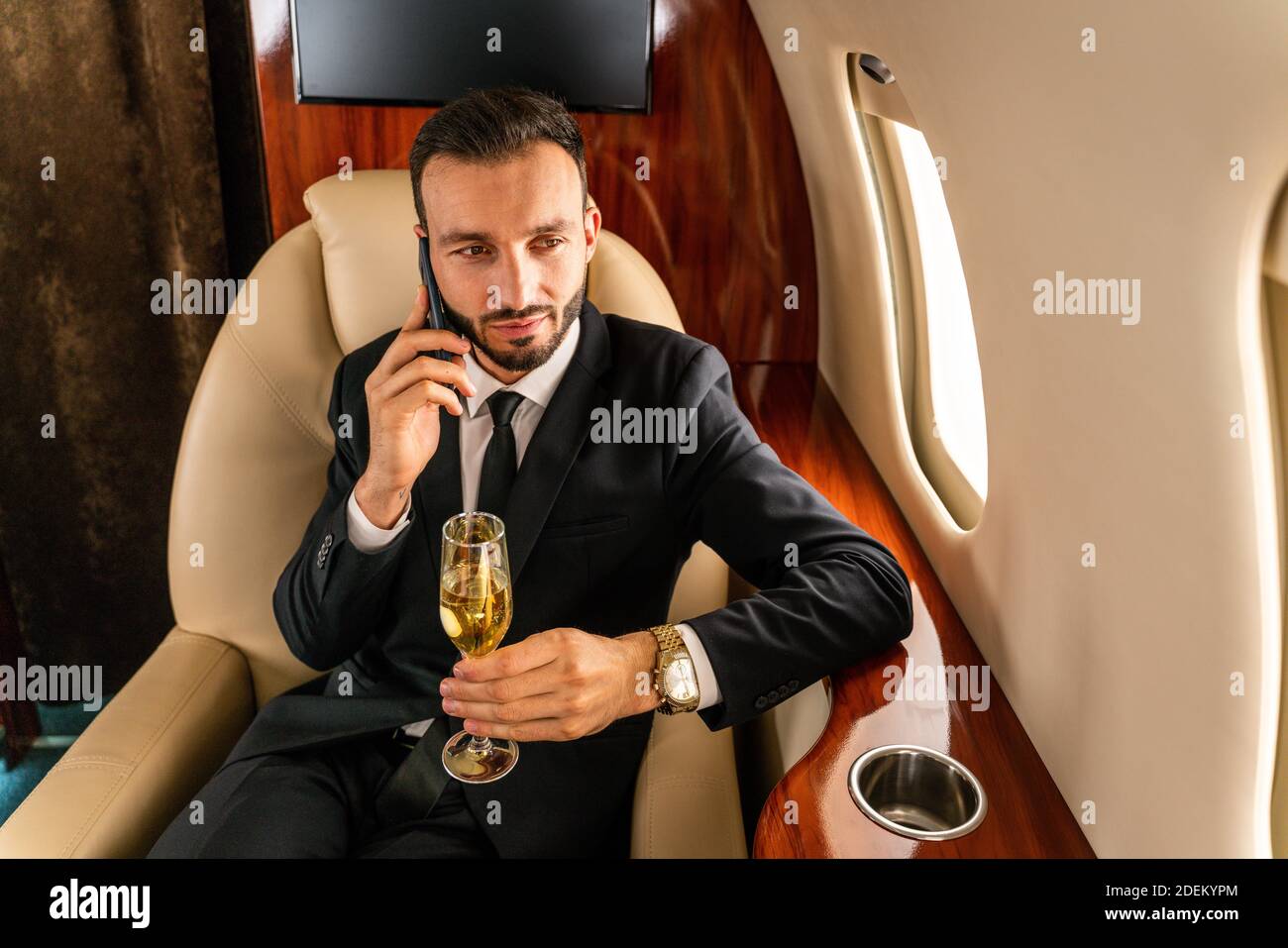 Handsome businessman wearing elegant suit flying on exclusive private ...