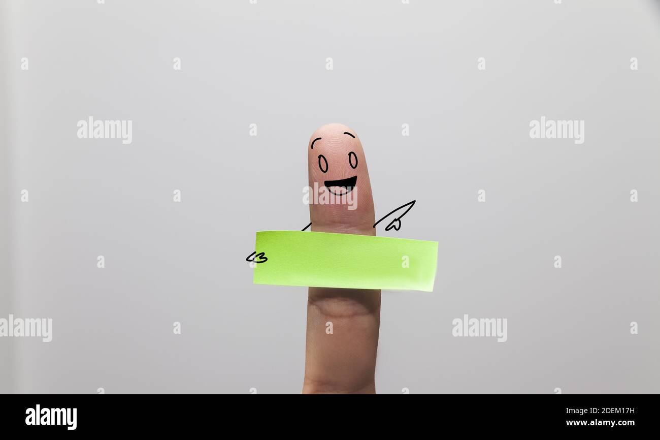 A happy finger holding a green piece of paper Stock Photo - Alamy