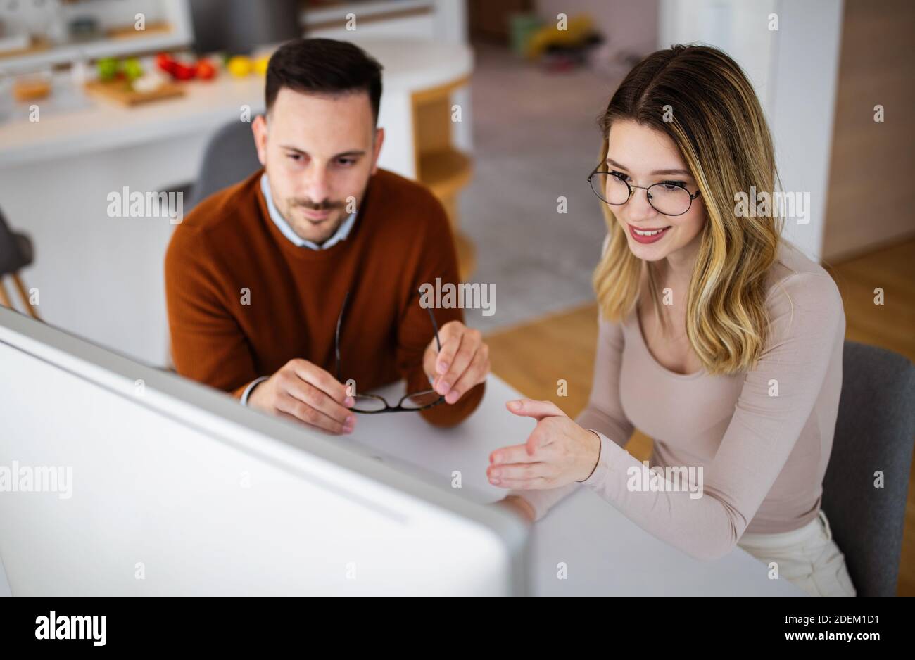 Positive couple having fun while working together remotely at home ...