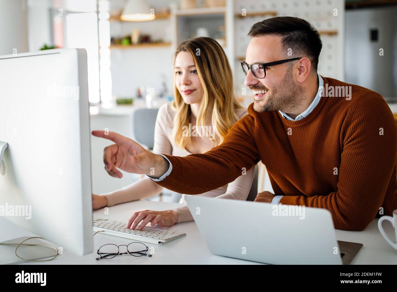 Graphic designers working in office with laptop. Team discussing ideas ...
