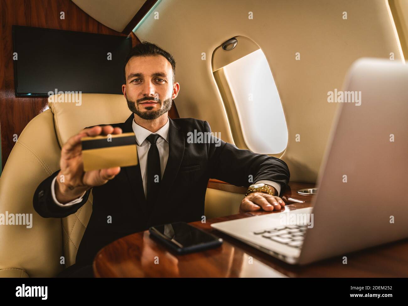 Handsome businessman wearing elegant suit flying on exclusive private ...