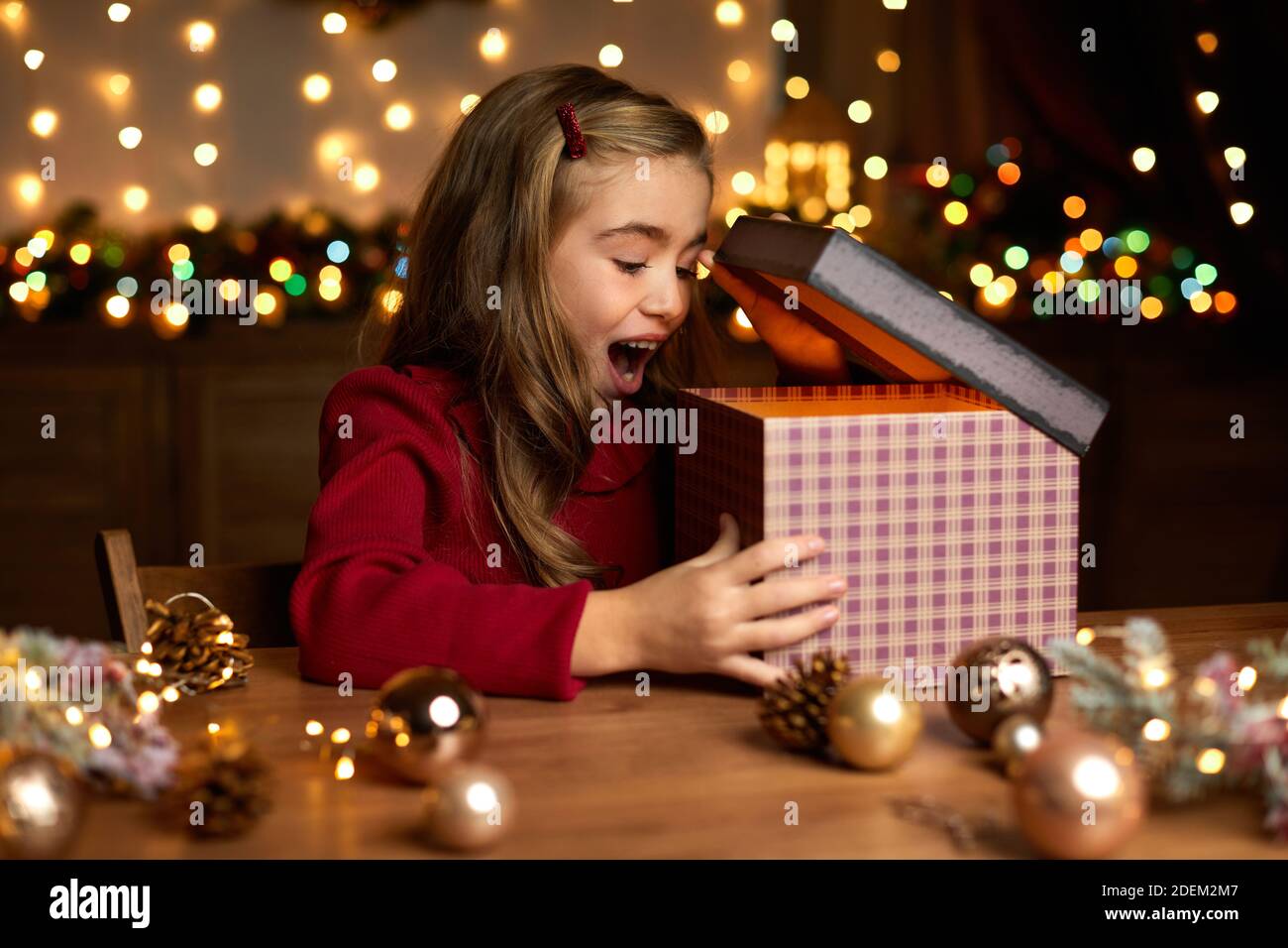beautiful surprised little child girl opening magic Christmas gift box ...